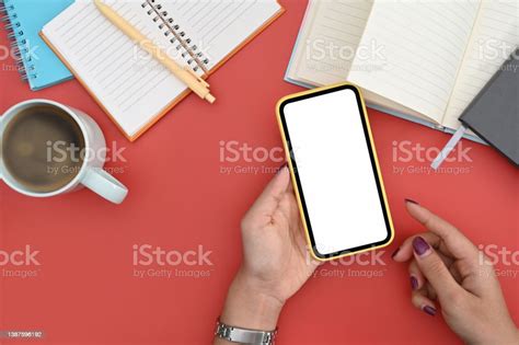 위에서 보기 에서 창조적 인 사무실에서 휴대 전화를 들고 여자 맨 위 보기입니다 Brand Name Smart Phone에 대한
