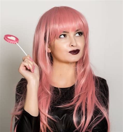 La Chica Joven Hermosa Con El Pelo Rosado La Sonrisa Y El Brigth Se Encienden Con El Lolipop