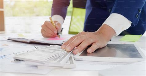 서류 가방과 태블릿으로 집중된 문서를 작업하는 사업가는 종이와 태블릿에 분석 데이터가 있는 테이블에 집중되어 있습니다 사진 Unsplash의 경제 이미지