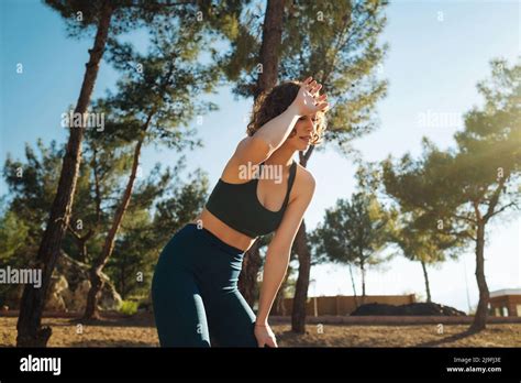 Young Redhead Woman Wearing Green Sports Bra And Blue Yoga Pants Standing On City Park After