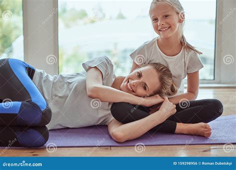 An Exhausted Mother Is Lying On Her Daughter After Heavy Yoga Classes