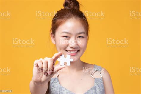 성공적인 비즈니스 및 연구 개념 노란 배경에 고립 된 조각 직소 퍼즐을 들고 여자의 클로즈업 이미지 개념에 대한 스톡 사진 및