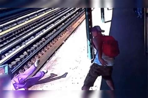 男子从身后接近路人女子，猛将她推下铁轨，现场画面曝光猛将铁轨路人