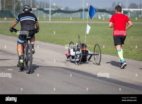 Disabled Athlete Who Trains With Her Hand Bike With Cyclist And Runners
