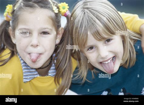 Girls Two Gesture Cheeky Tongue Stick Out Portrait Outside