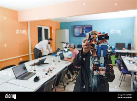 A Group Of Colleagues Working Together In A Robotics Laboratory