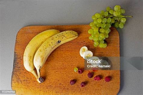 회색 배경에 나무 도마에 녹색 포도와 라즈베리가 잔뜩 있는 바나나 다발 가정 주방에 대한 스톡 사진 및 기타 이미지 가정