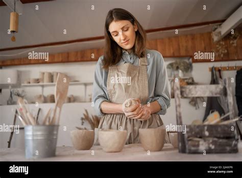 Female Artisan Concentrated On Modeling Jug From Raw Clay While Pottery