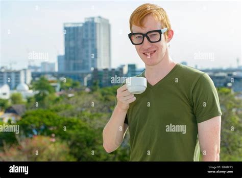 Happy Nerd Man With Red Hair Drinking Coffee Against View Of The City Stock Photo Alamy