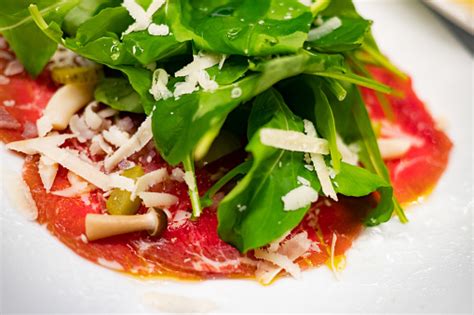 맛 있는 하 고 건강 한 원시 음식입니다 흰색 라운드 접시에 Carpaccio 디 Manzo 또는 쇠고기 카르파치오 0명에 대한