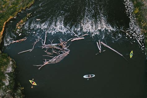 People Kayak On River With Waterfall Drone Photograph Of Adventure