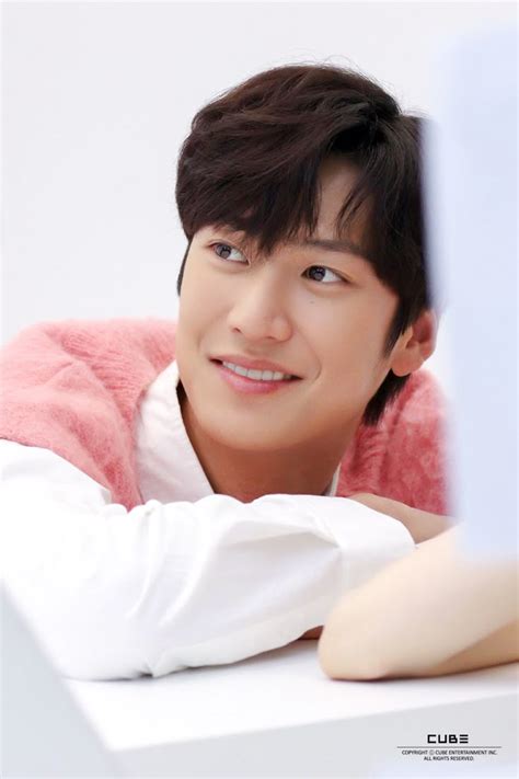 The Young Man Is Wearing A Pink Sweater And Smiling At The Camera While