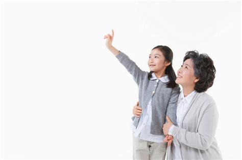 东方人儿童老年人两个人家庭祖母站举笑微笑露齿笑横图室内白天白色背景正面纯洁亚洲服装挥手注视休闲装