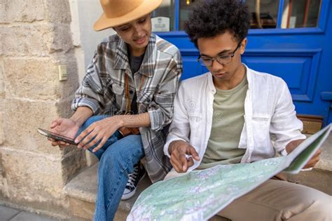 Young Couple Scrutinizing The Map And Searching For The Route Stock