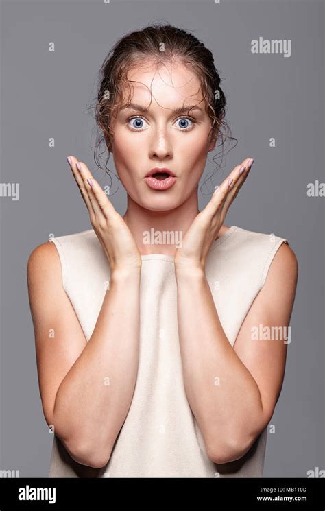 Amazed Young Woman With Hands Near Face And Mouth Open Shocked Girl