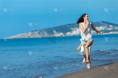 一对快乐的情侣在沙滩上跑步