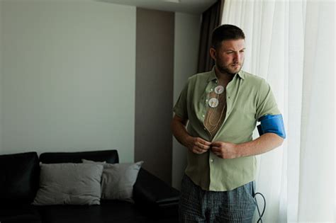 심장 강화 모니터를 가진 젊은 남자가 옷을 입습니다 심장의 작업에 대한 연구 심장학 홀터 모니터 의료 진단 건강 관리 병원 심전도 센서 심전도 및 혈압 측정 가정 생활에