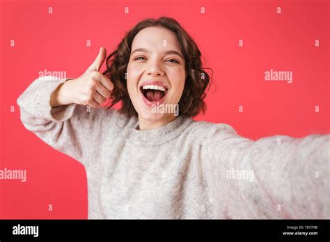 Portrait Of A Cheerful Young Woman Standing Isolated Over Pink