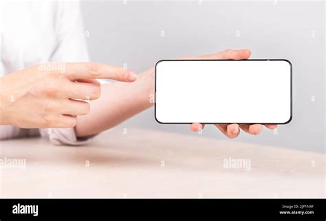 Woman Forefinger Pointing To Phone Mockup In Horizontal Position