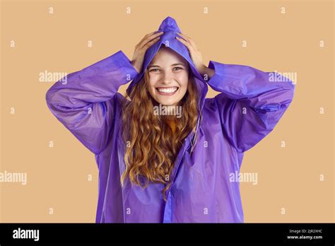 Happy Cheerful Pretty Young Woman In A Purple Raincoat Having Fun While