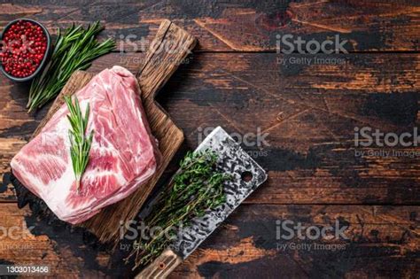 정육점 칼로 나무 도마에 신선한 스테이크를 위한 돼지 고기 어깨 생 고기 어두운 나무 배경 맨 위 보기입니다 복사 공간 고기