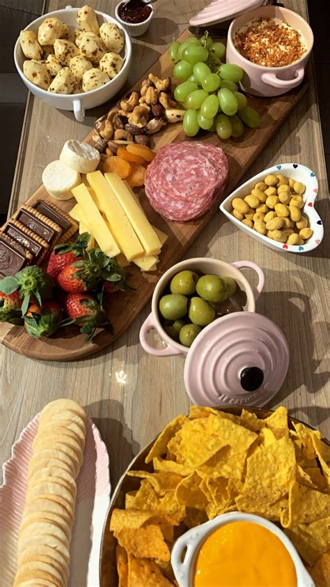 A Wooden Table Topped With Lots Of Different Types Of Food And Snacks