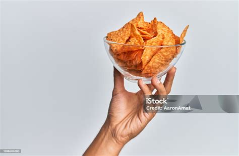 고립 된 흰색 배경 위에 멕시코 나초 감자와 그릇을 들고 히스패닉 남자의 손 스낵에 대한 스톡 사진 및 기타 이미지 스낵