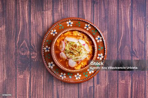 전통적인 멕시코 음식 아보카도 양상추 양파 무 레몬 칠리 바삭바삭한 옥수수 토르티야와 함께 닭고기를 곁들인 붉은 포졸 수프는 나무 배경에 토스타다라고도 합니다 Pozole에