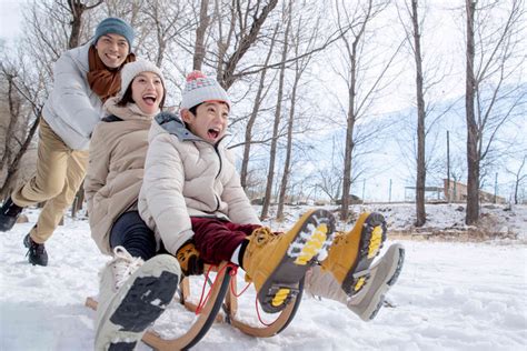 在雪地上玩雪橇的一家人 包图企业站