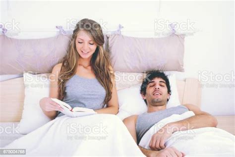 부부 침대에서 웃 고입니다 남자 여자는 책을 읽는 동안 잔 다 2명에 대한 스톡 사진 및 기타 이미지 2명 갈색 머리
