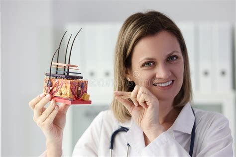 Smiling Female Dermatologist Holding Artificial Human Skin Model And