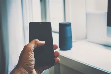 Premium Photo Smartphone In Hand Speaker Router Computer On Desk