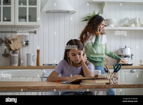 Independent Smart Teen Girl Making Homework Sits At Table In Dining