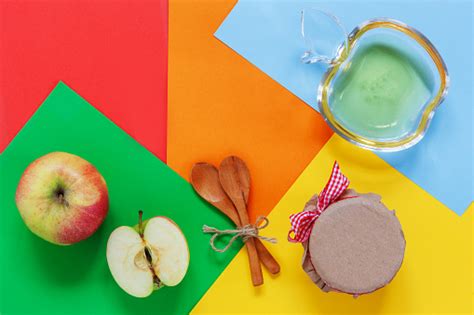 사과와 꿀 유대인의 새해로 로쉬 하샤나에 대한 개념 밝은 여러 가지 색상의 종이 배경에 클로즈업 한 상단 보기 가을에 대한 스톡