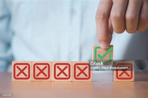 적십자 마크 중 녹색 올바른 기호 표시를 들고 있는 사업가는 사업 제안 개념을 승인하고 거부하기 위해 나무 큐브 블록에 화면을