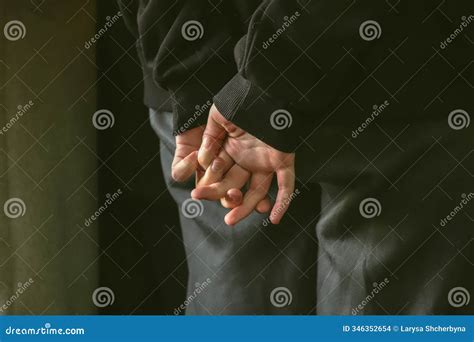 Teenager Nervously Wrings His Fingers Holding His Hands Behind His