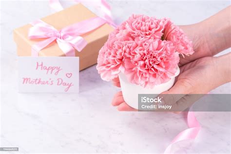 디자인 컨셉대리석 흰색 바탕에 카네이션 꽃다발을 주는 여자 평면도 복사 공간 클로즈업 모의 어머니의 날 아이디어 영감 갈색