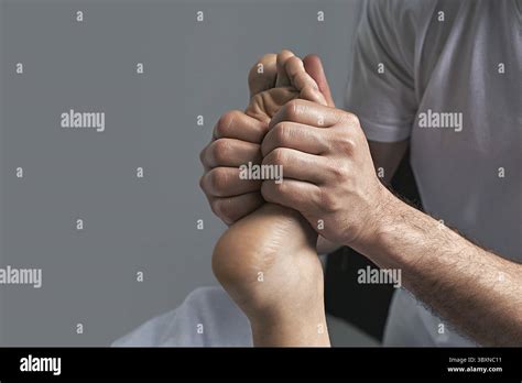 Male Masseur Hands Doing Reflexology Massage On Female Foot Reflex