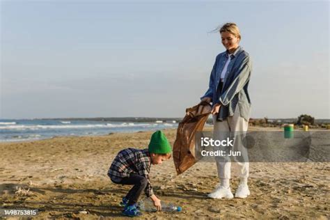 백인 가족은 해변에서 플라스틱 쓰레기를 수거하고 있다 어머니는 아들에게 자연을 깨끗하게 유지하도록 가르치고 있습니다 18 23 개월에 대한 스톡 사진 및 기타 이미지