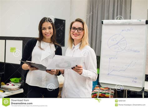 Dos Ejecutivos Jovenes Hermosos Que Leen Algunos Papeles Imagen De Archivo Imagen De