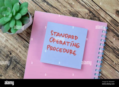 Concept Of Standard Operating Procedure Write On Sticky Notes Isolated On Wooden Table Stock
