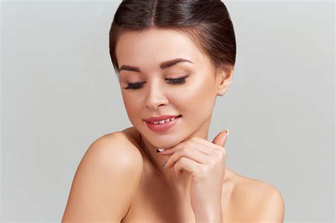 페이셜 케어 크림을 바르고 웃는 여자 아름다움 얼굴입니다 젊은 여자의 초상화입니다 부드러운 피부에 미용 제품과 아름 다운 여자의