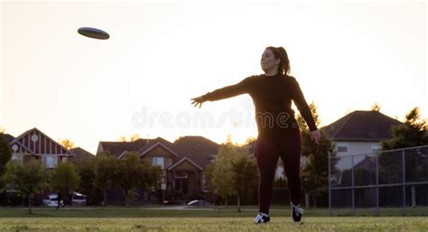 White Caucasian Adult Girl Playing Frisbee In The Green Field Stock