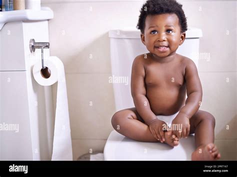 Im Ready For My First Potty Training Lesson An Adorable Baby Babe Sitting On The Toilet In The