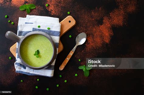 녹색 완두콩과 브로콜리의 신선한 수제 다이어트 크림 수프가 민트와 함께 제공됩니다 어두운 소박한 배경입니다 맨 위 보기 건강한