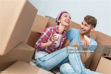 젊은 부부는 새로운 장소로 이동 농담 즐거운 지주 샌드위치와 차를 웃 고 앉아 남자에 대한 스톡 사진 및 기타 이미지 남자 상자 이주 개념 Istock