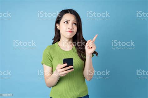 푸른 배경에 고립 된 전화를 들고 있는 어린 아시아 소녀의 초상화 25 29세에 대한 스톡 사진 및 기타 이미지 25 29세
