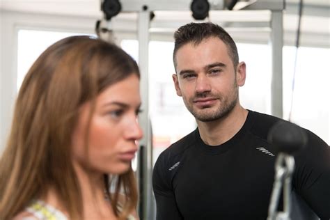 Premium Photo | Personal trainer helping client in gym