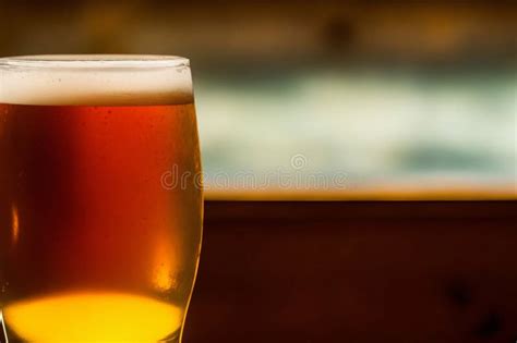 A Glass Of Beer Sitting On Top Of A Table Generative Ai Stock