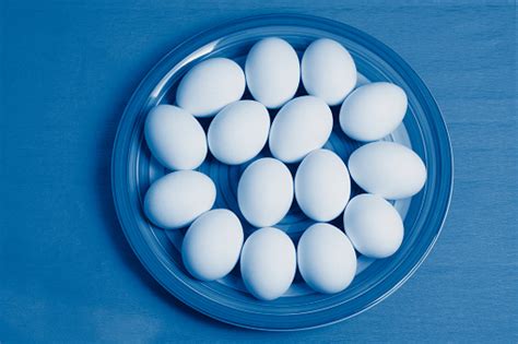 화려한 접시와 파란색 배경에 부활절 달걀입니다 2020 년 올해의 클래식 블루 트렌디 한 색상의 톤 단백질에 대한 스톡 사진 및